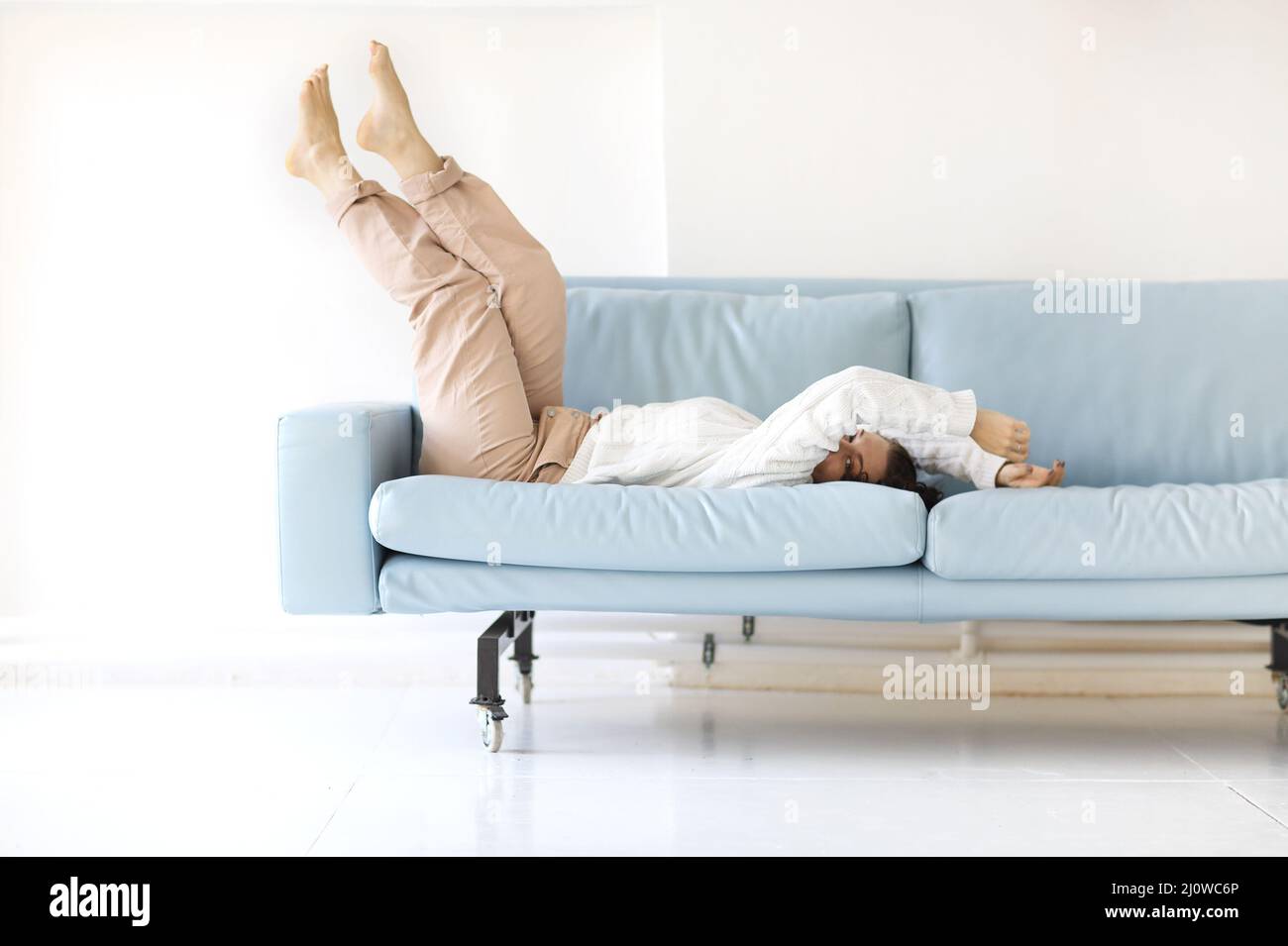 Photo of young cheerful woman in casual clothes falling on blue cozy ...