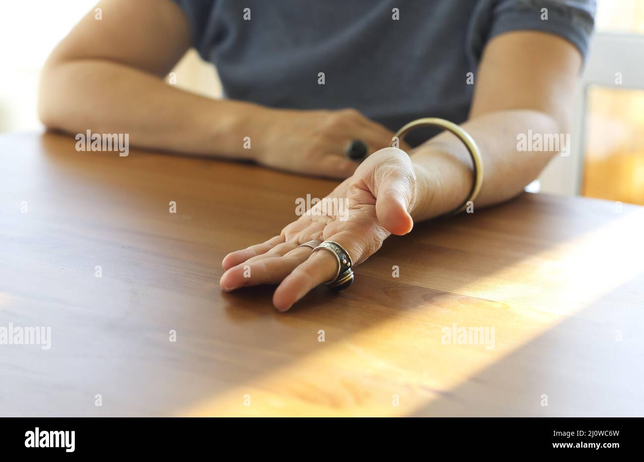 Mature woman showing her palm with life lines to chiromancer or palmist ...