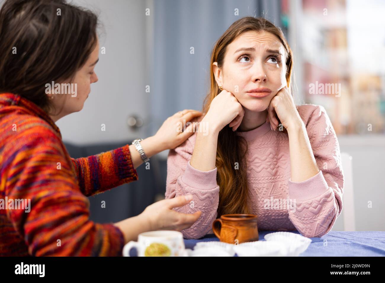 Woman helping and consoling her female friend Stock Photo - Alamy