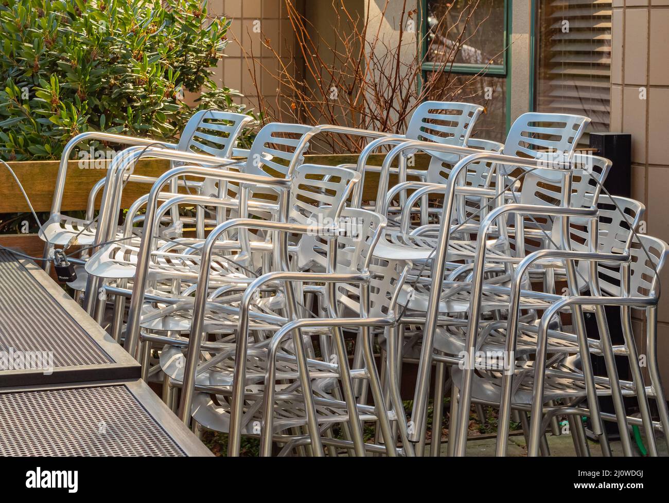 Close-up on a pile of aluminum chairs. Pile of chairs at the backyard ...
