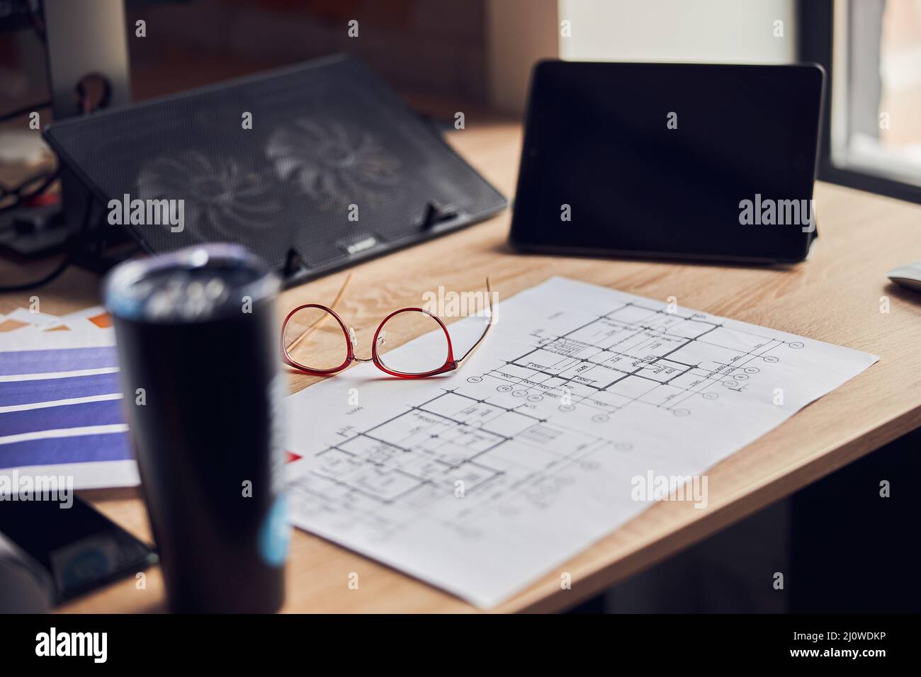 Close up shot of tablet pc, architectural blueprint with papers and ...
