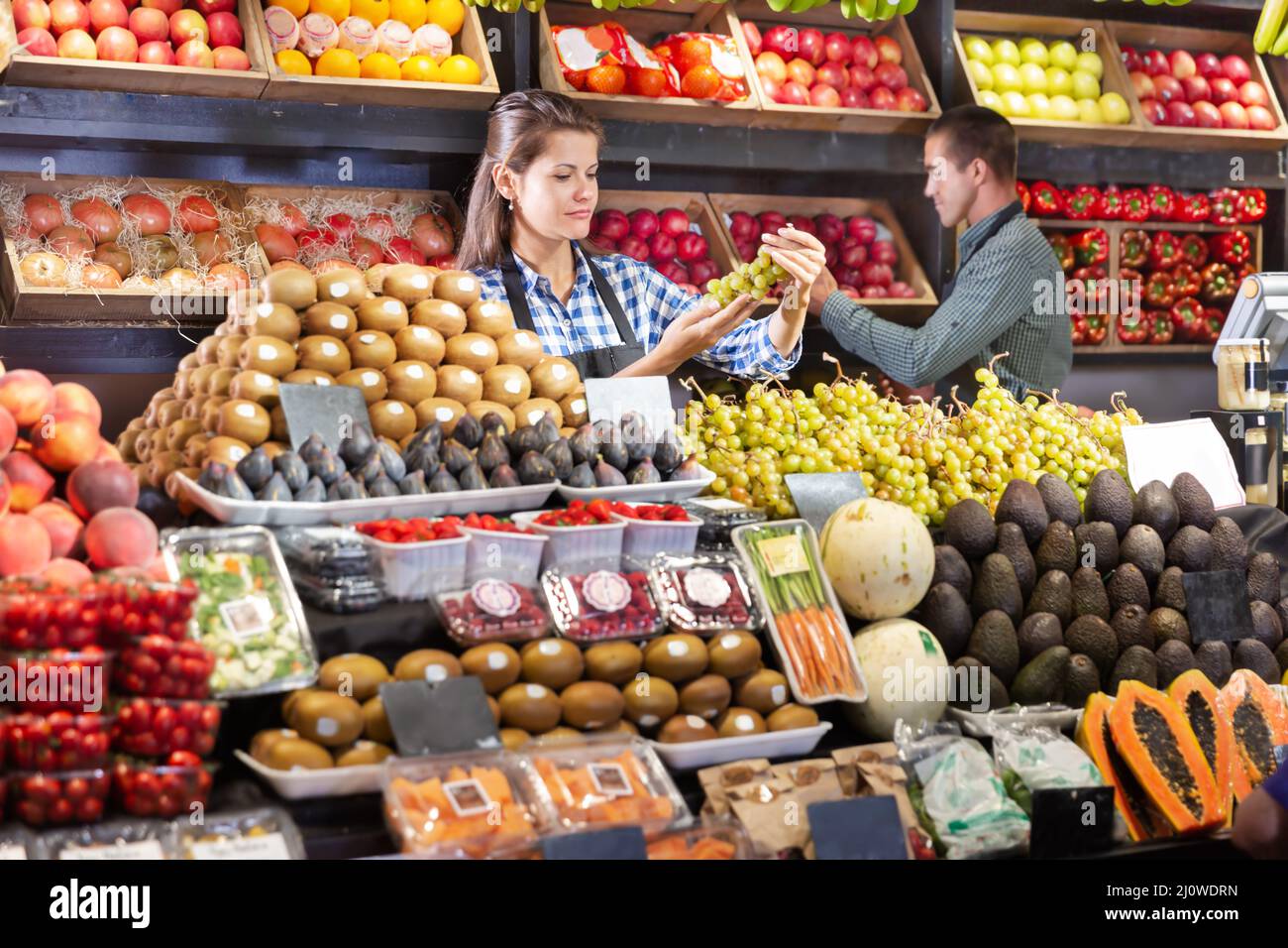 Woman selling grapes and fruits on the supermarket Stock Photo - Alamy