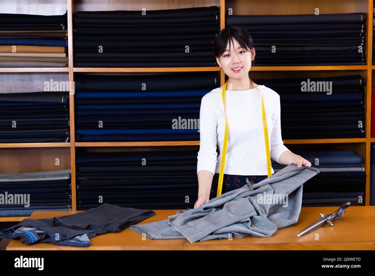 Saleswoman offering cloth in textile shop Stock Photo - Alamy