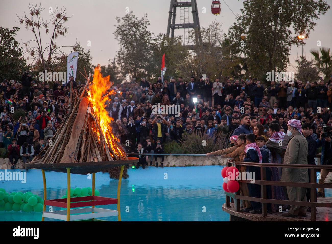 Erbil, Iraq. 20th Mar, 2022. People gather around a bonfire during a ...
