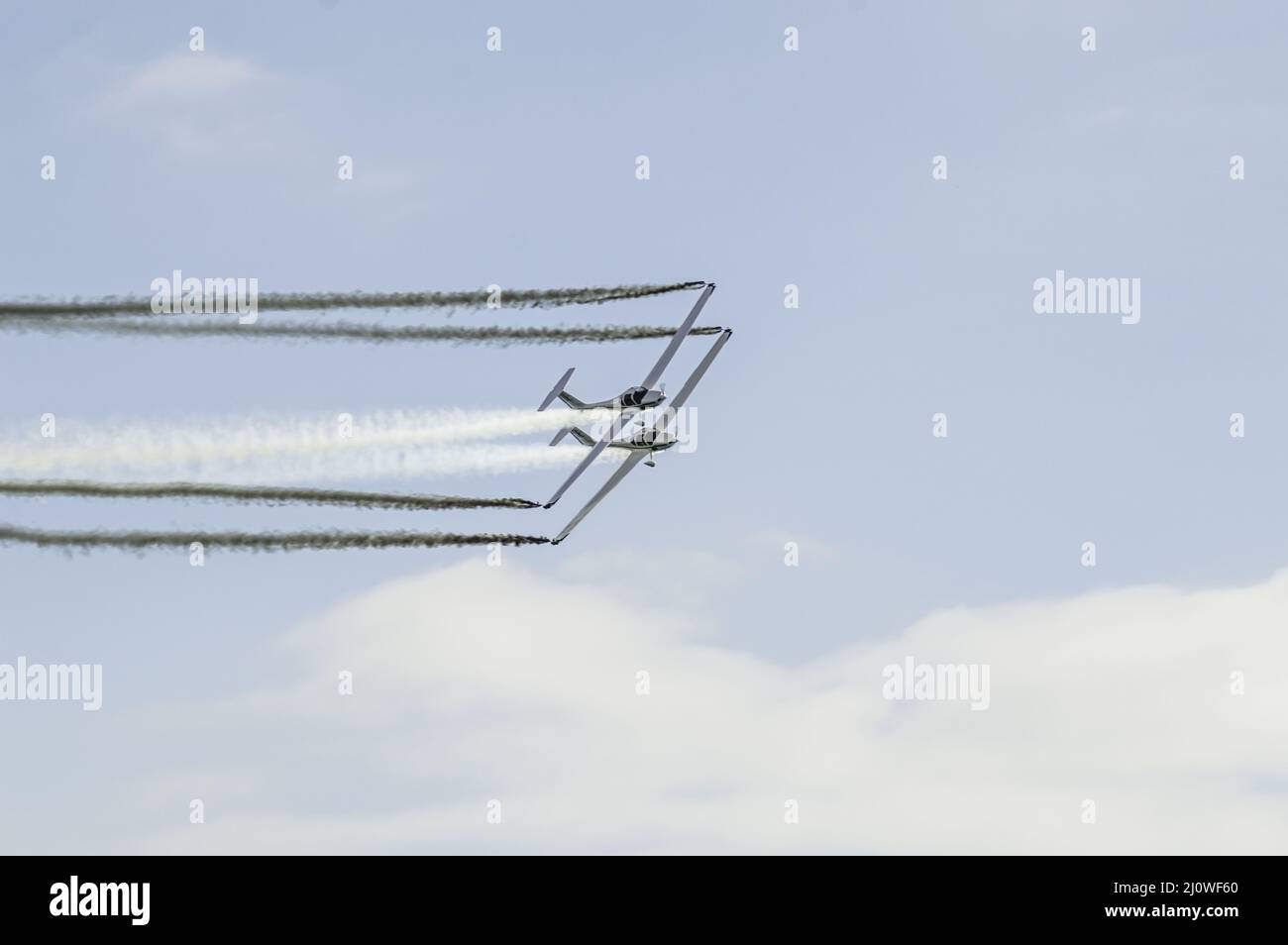 Twin plane acrobatics performance in the sky with smoke Stock Photo - Alamy