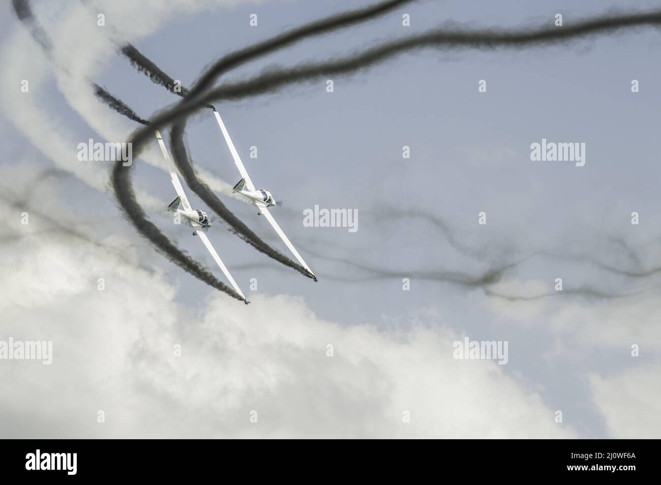 Twin plane acrobatics performance in the sky with smoke Stock Photo - Alamy