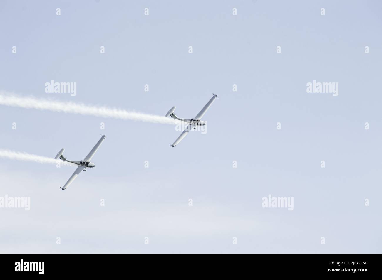 Twin plane acrobatics performance in the sky with smoke Stock Photo - Alamy