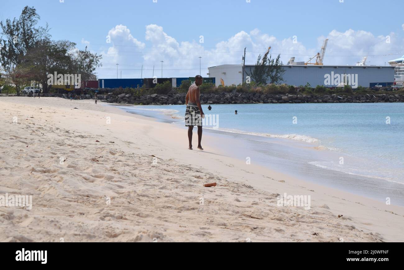 Beach view with local people in Barbados Stock Photo - Alamy
