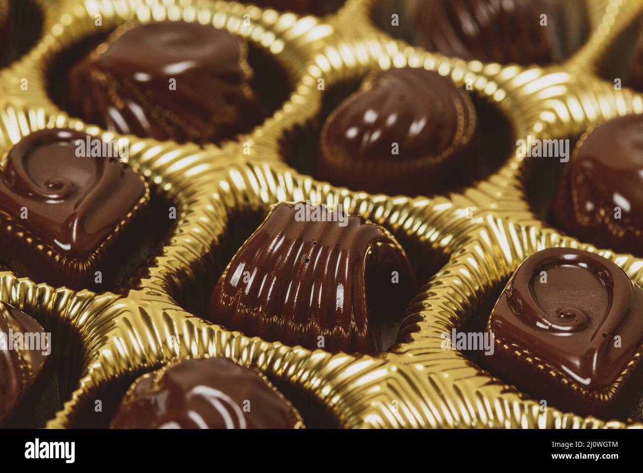 Variety kind of chocolate pralines in a golden box Stock Photo - Alamy