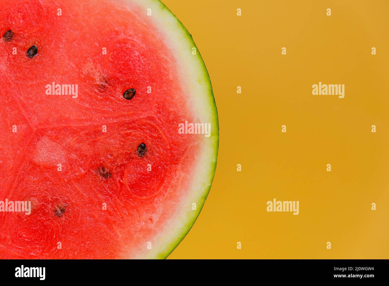 Watermelon pulp. Watermelon cut on a yellow background.Fresh ripe red ...