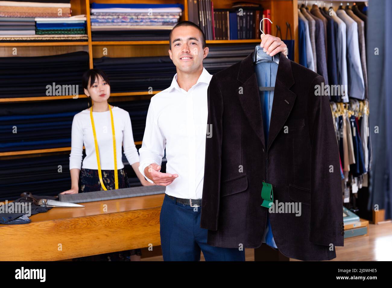 Happy man holding classic jacket in clothing store Stock Photo - Alamy