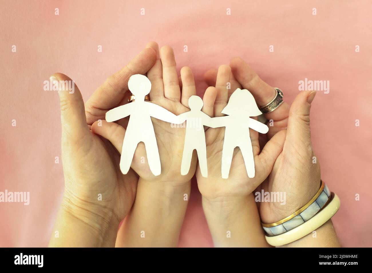 Parents and kid holding family paper cut out in hands. Celebrating ...