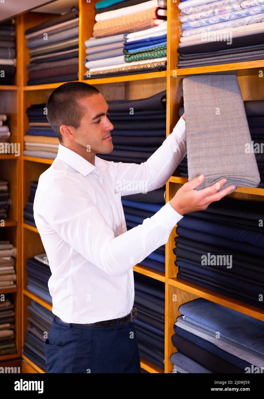 Salesman offering textiles in shop Stock Photo - Alamy