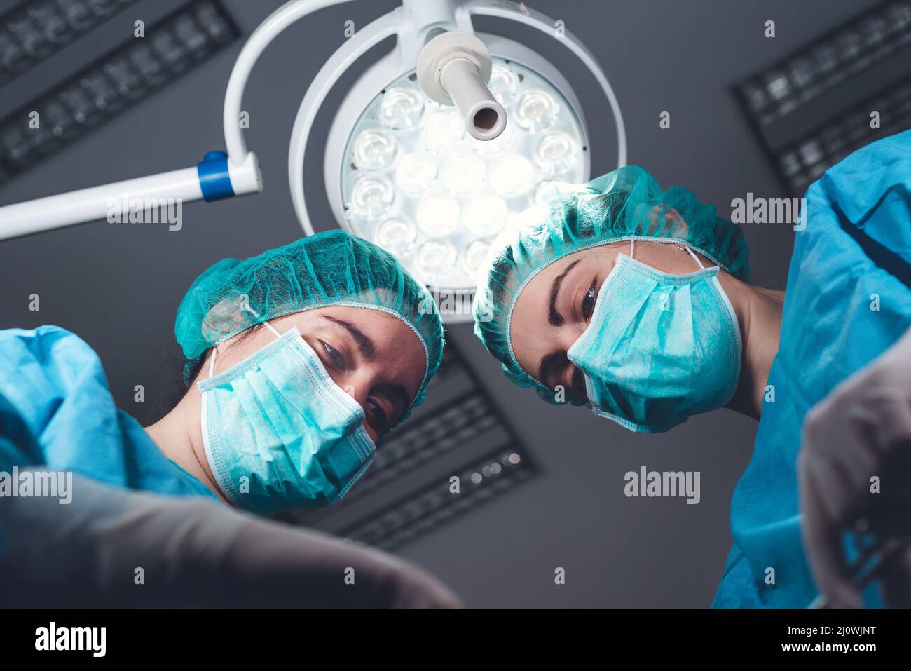 From below female surgeons in medical uniform using professional tools ...