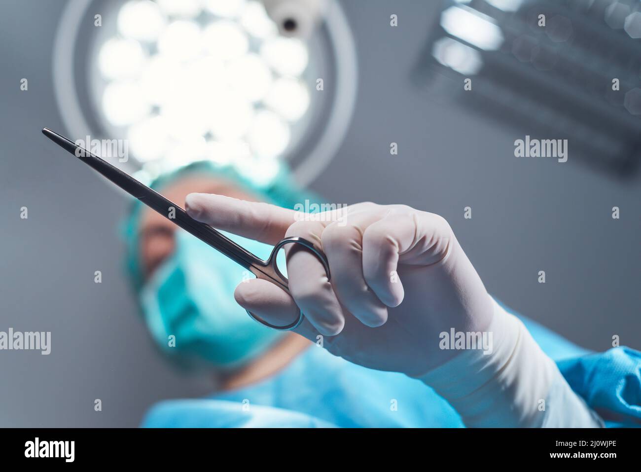 From below woman surgeon in medical uniform using professional tools ...