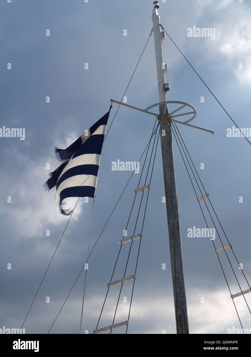 Tettered Greek flag flying from boat's mast at Astrakeri, Corfu, Greece ...