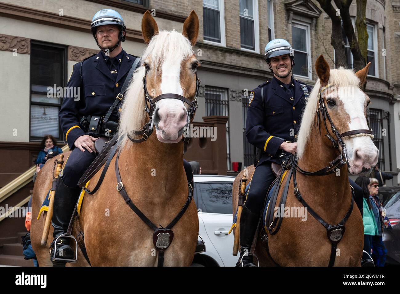 Two NYPD mounted unit horses and officers keep an eye on revelers ...
