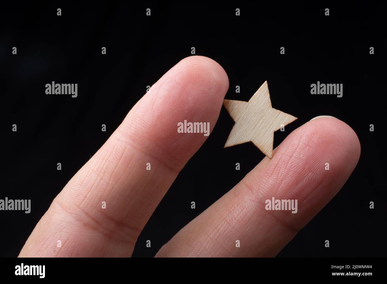 The hand holding a wooden star Stock Photo - Alamy