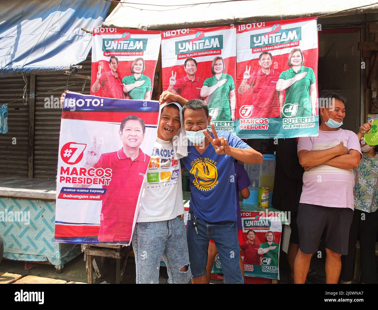 Two male Marcos supporters show their streamer and flashing a V sign ...