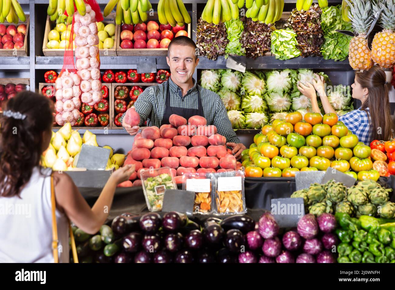 Shop assistants selling fruits and vegetables to buyer Stock Photo - Alamy