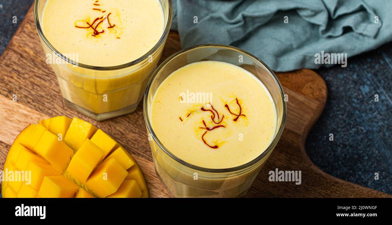 Drink mango lassi in two glasses on rustic concrete table with fresh ...