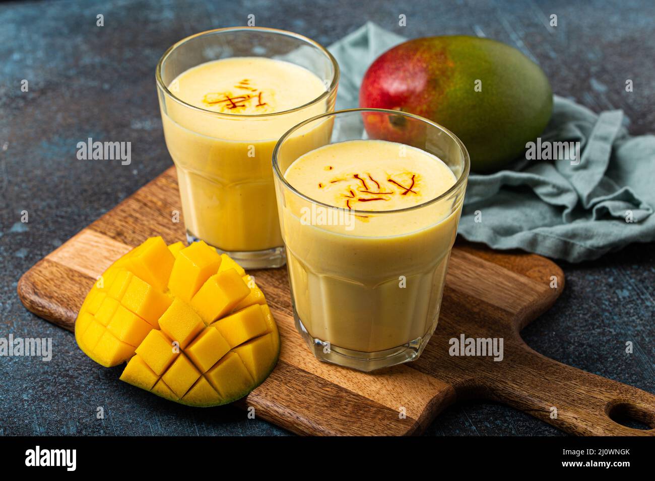Drink mango lassi in two glasses on rustic concrete table with fresh ...