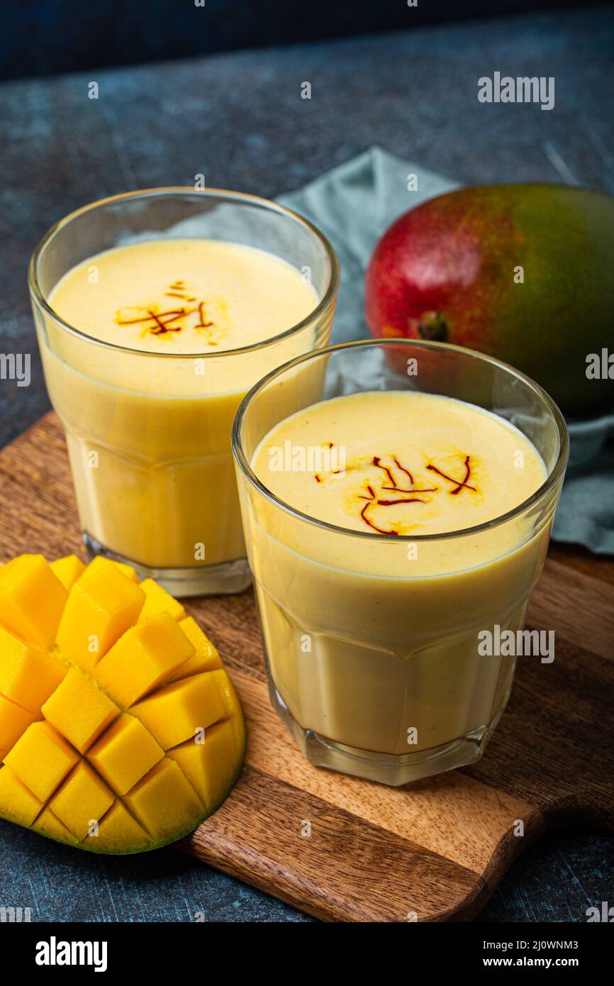 Drink mango lassi in two glasses on rustic concrete table with fresh ...