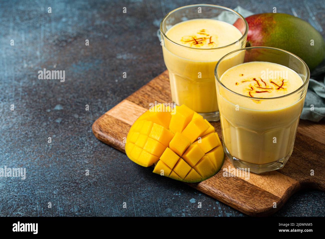 Drink mango lassi in two glasses on rustic concrete table with fresh ...