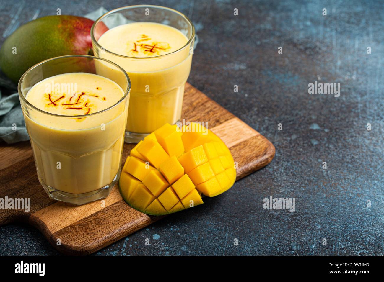 Drink mango lassi in two glasses on rustic concrete table with fresh ...