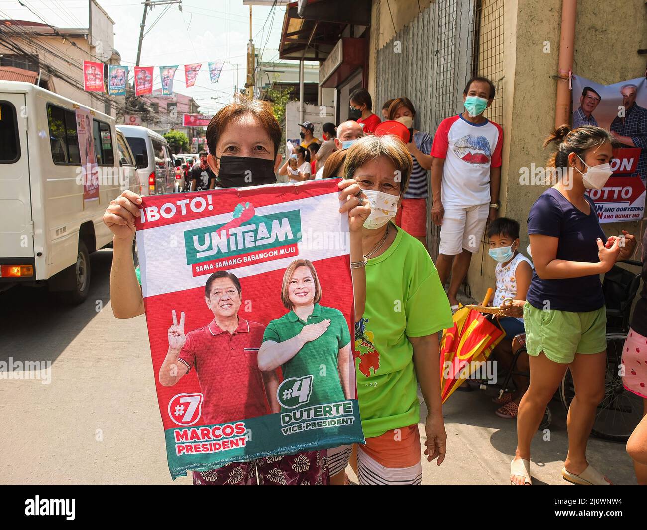 Two women hold their UniTeam's campaign poster. Bongbong Marcos Jr ...