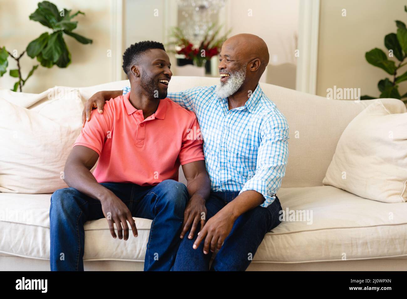 African american father and son smiling looking at each other sitting ...