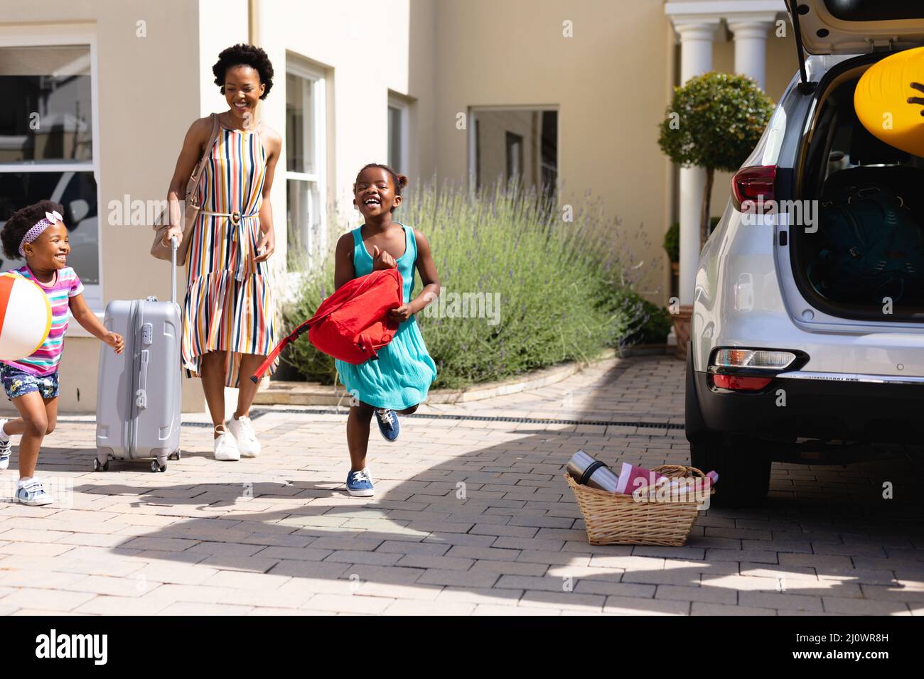 African american mother and her daughters walking towards their car ...