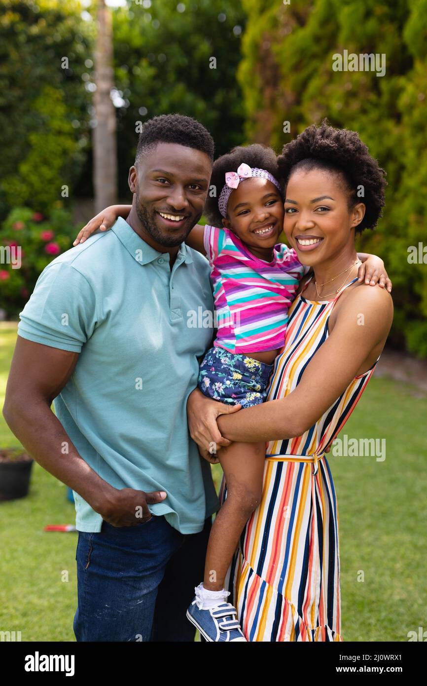 Portrait of smiling african american parents carrying daughter at ...
