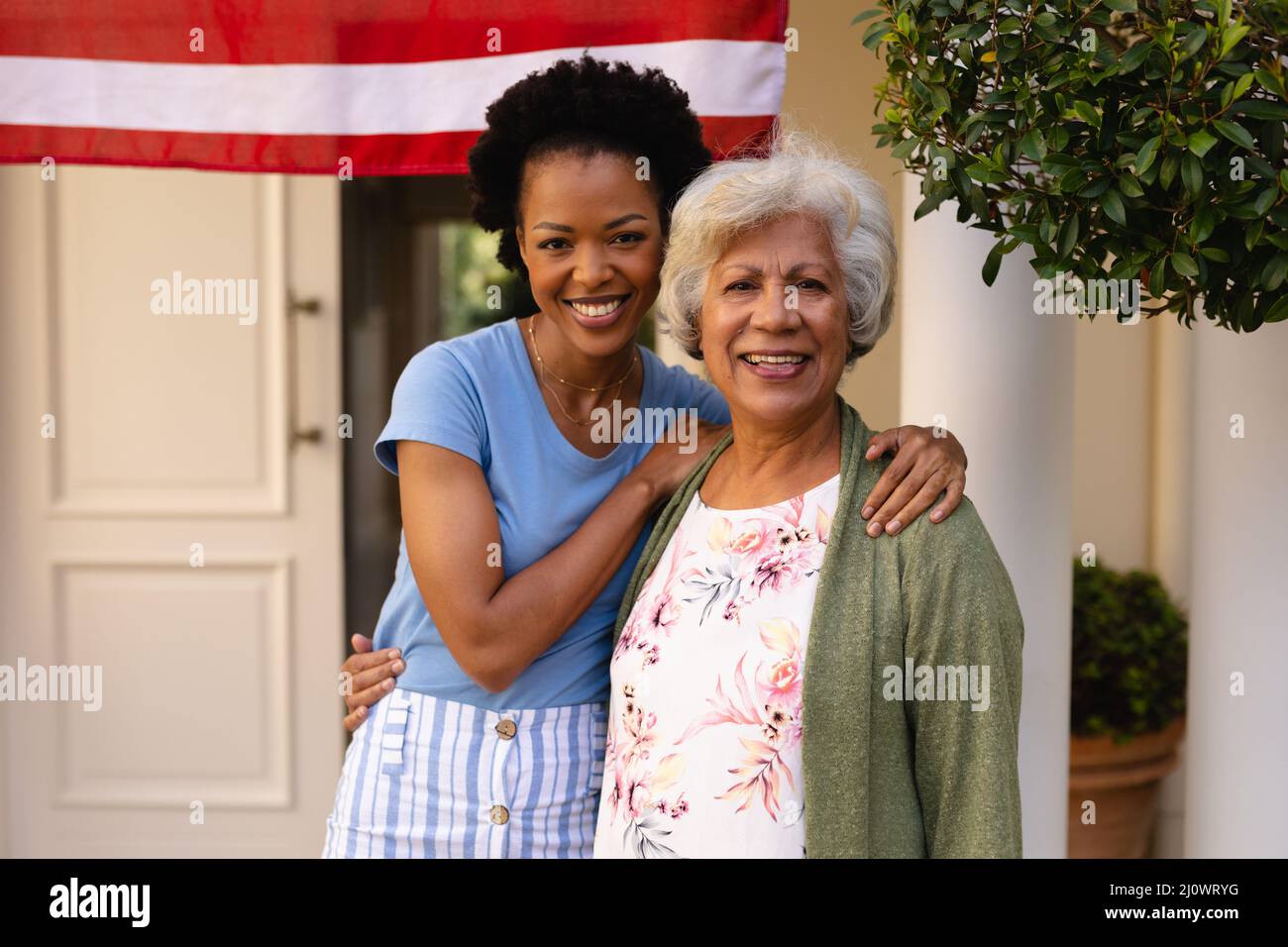 Portrait of smiling african american daughter with arm around mother at ...