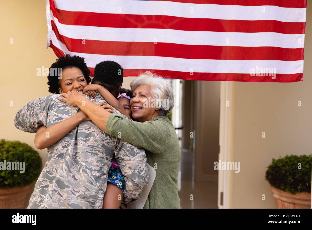 Happy african american family embracing military soldier's return at ...
