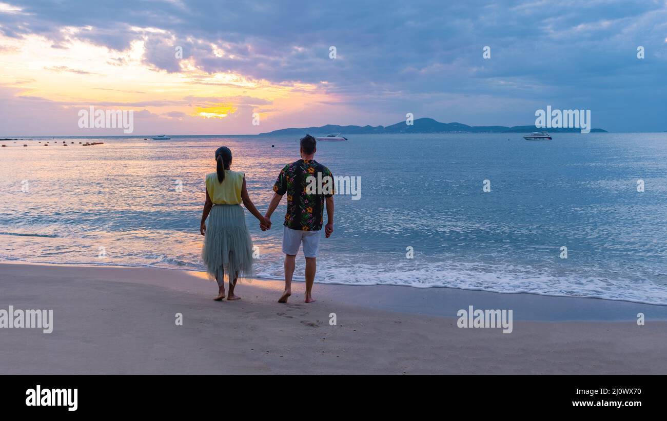 Sunset on Cosy Beach Pattaya Thailand , couple man and woman walking on ...