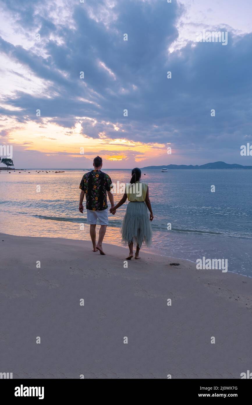 Sunset on Cosy Beach Pattaya Thailand , couple man and woman walking on ...