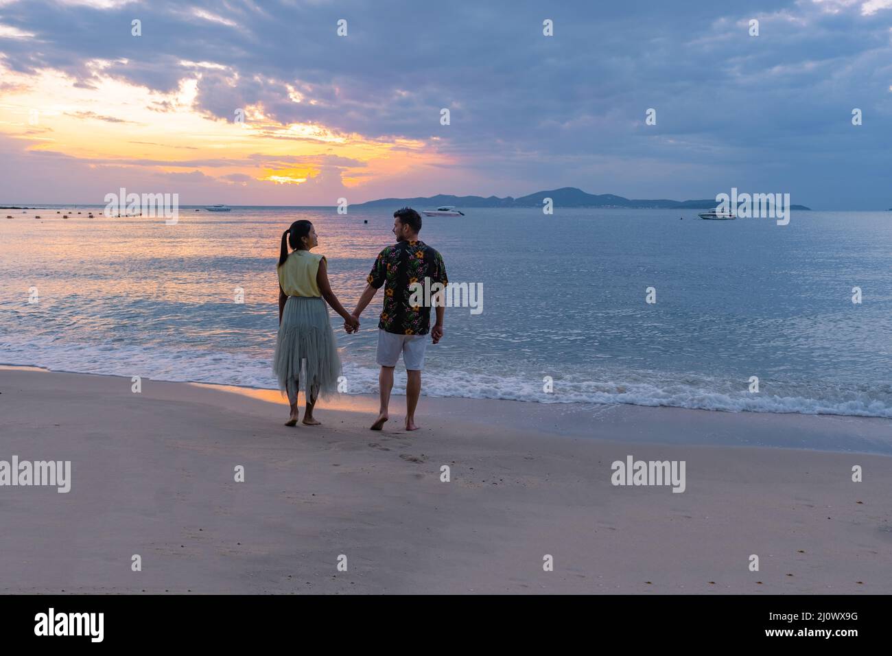 Man and woman walking into sunset hi-res stock photography and images ...
