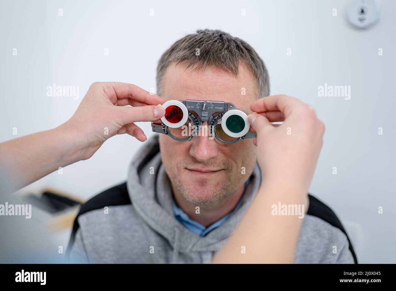 Examining patient vision. Eye exam. Optometrist checking patient ...