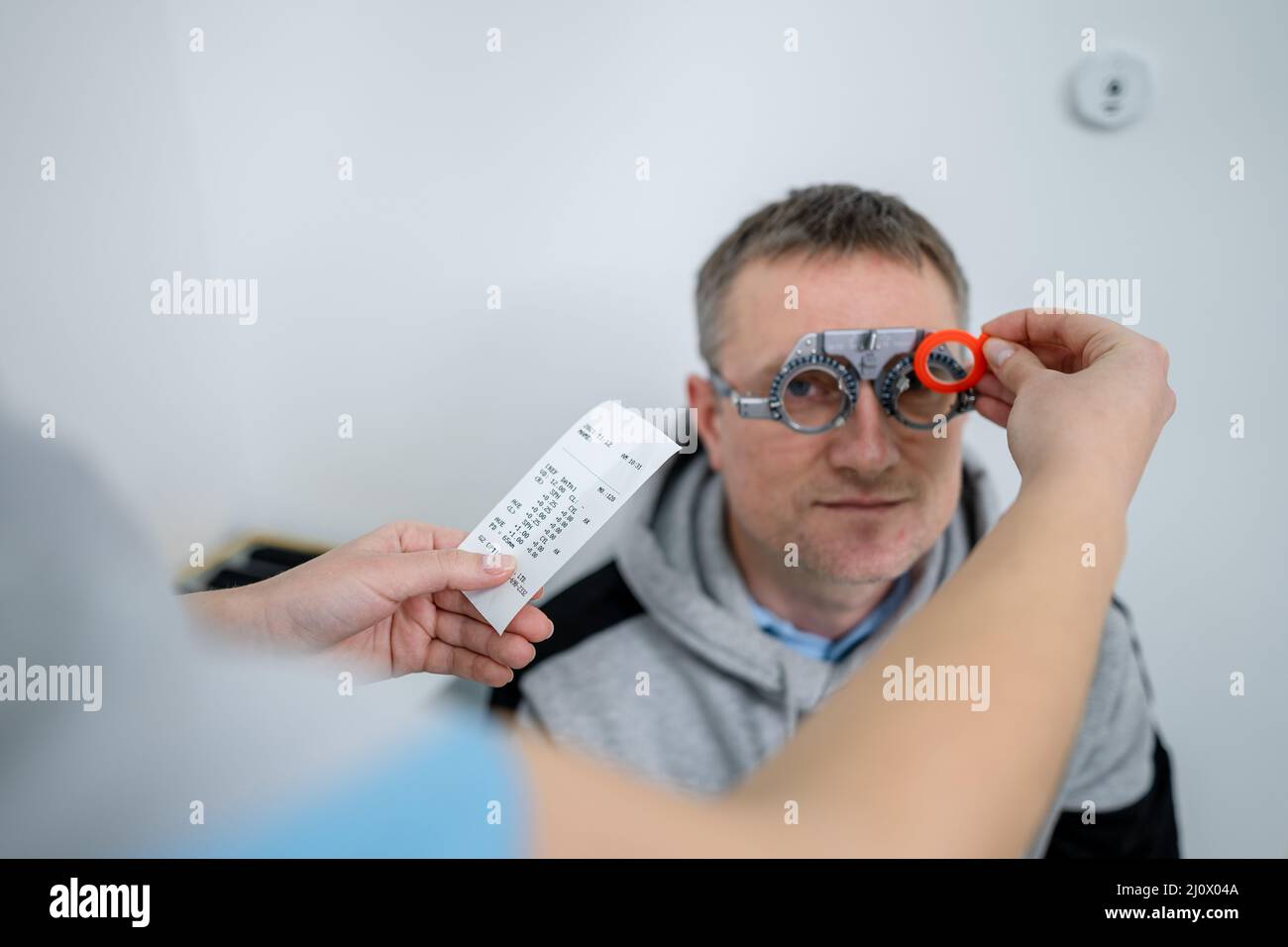 Examining patient vision. Eye exam. Optometrist checking patient ...