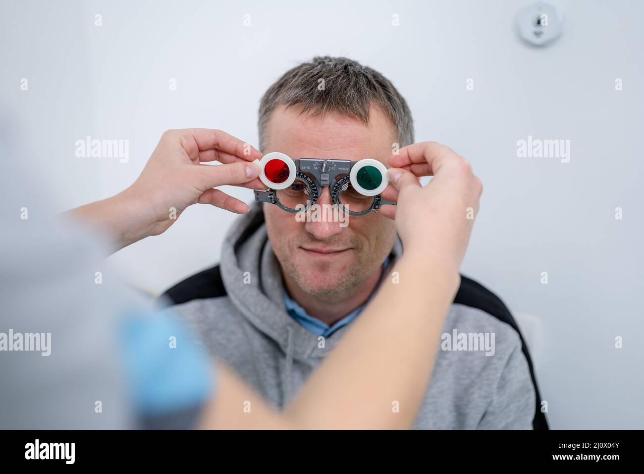 Examining patient vision. Eye exam. Optometrist checking patient ...