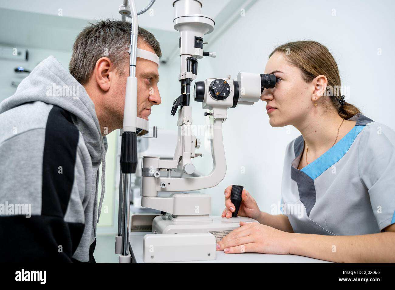 Ophthalmologist and patient testing eyesight. Man doing eye test with ...