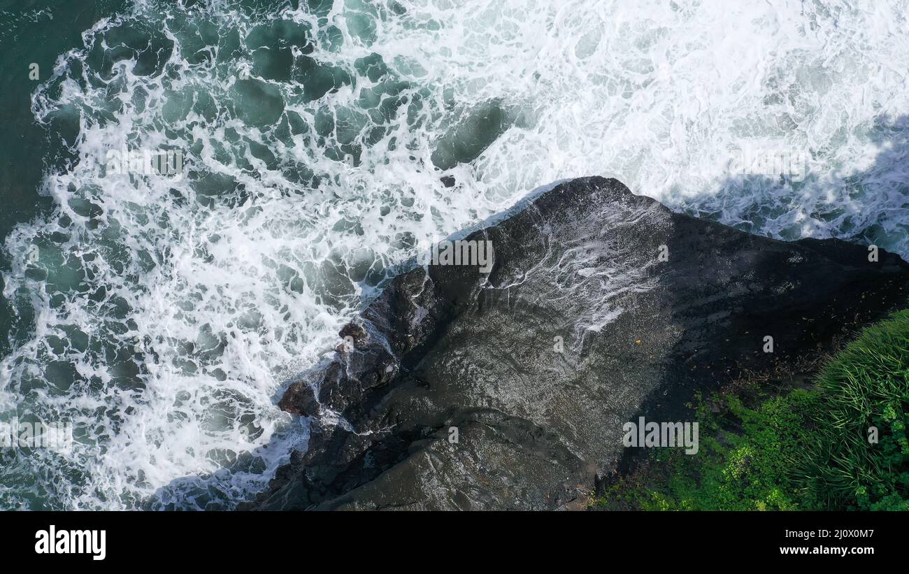 Waves breaking on the rocky shore of Balenese Hindu temple in Tanah Lot ...