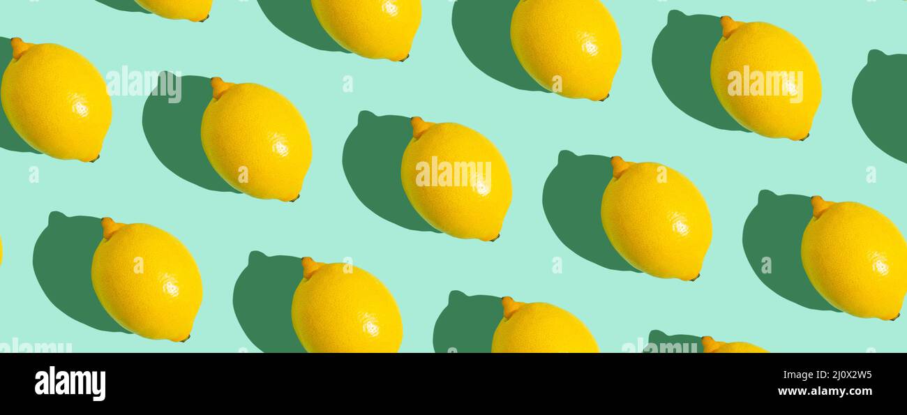 Yellow whole lemons on minimal blue background on bright sun light with ...