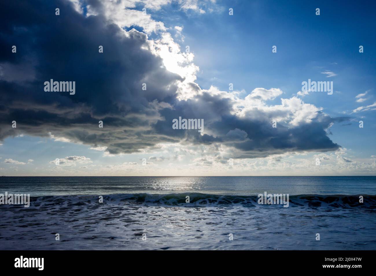 Cloudy seascape view from a beach at sunset Stock Photo - Alamy