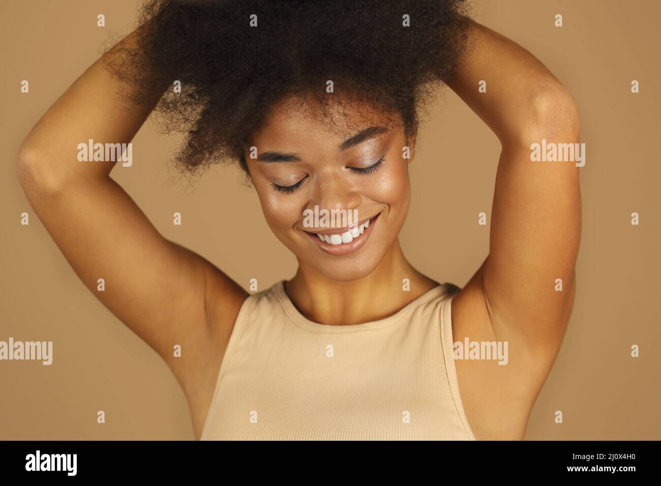 Young lovely african american woman with arms raised demonstrating ...