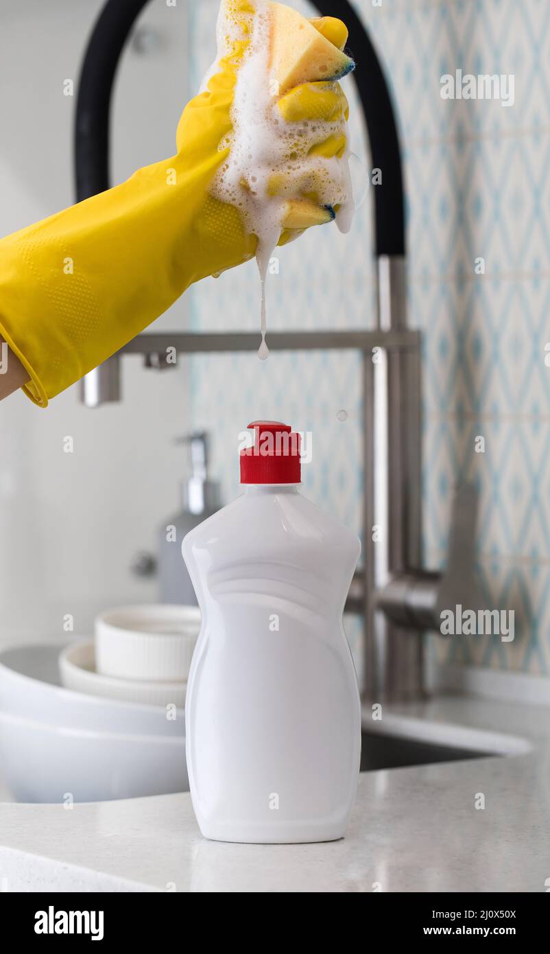 White bottle with dishwashing gel against the background of a sink and ...