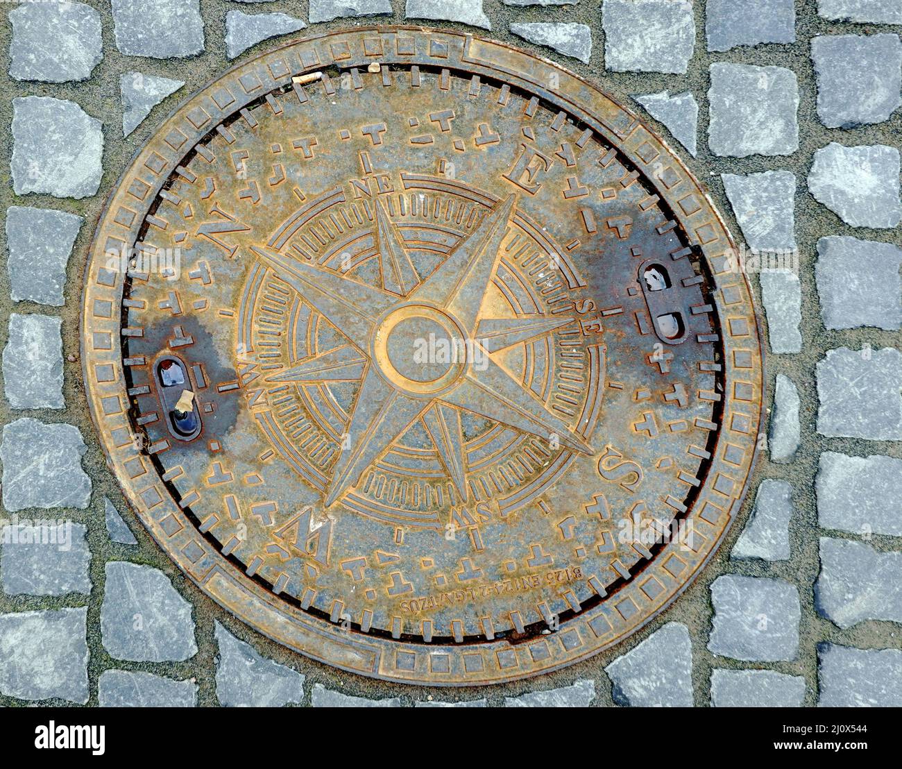 Wind rose or compass rose on a manhole cover Stock Photo - Alamy