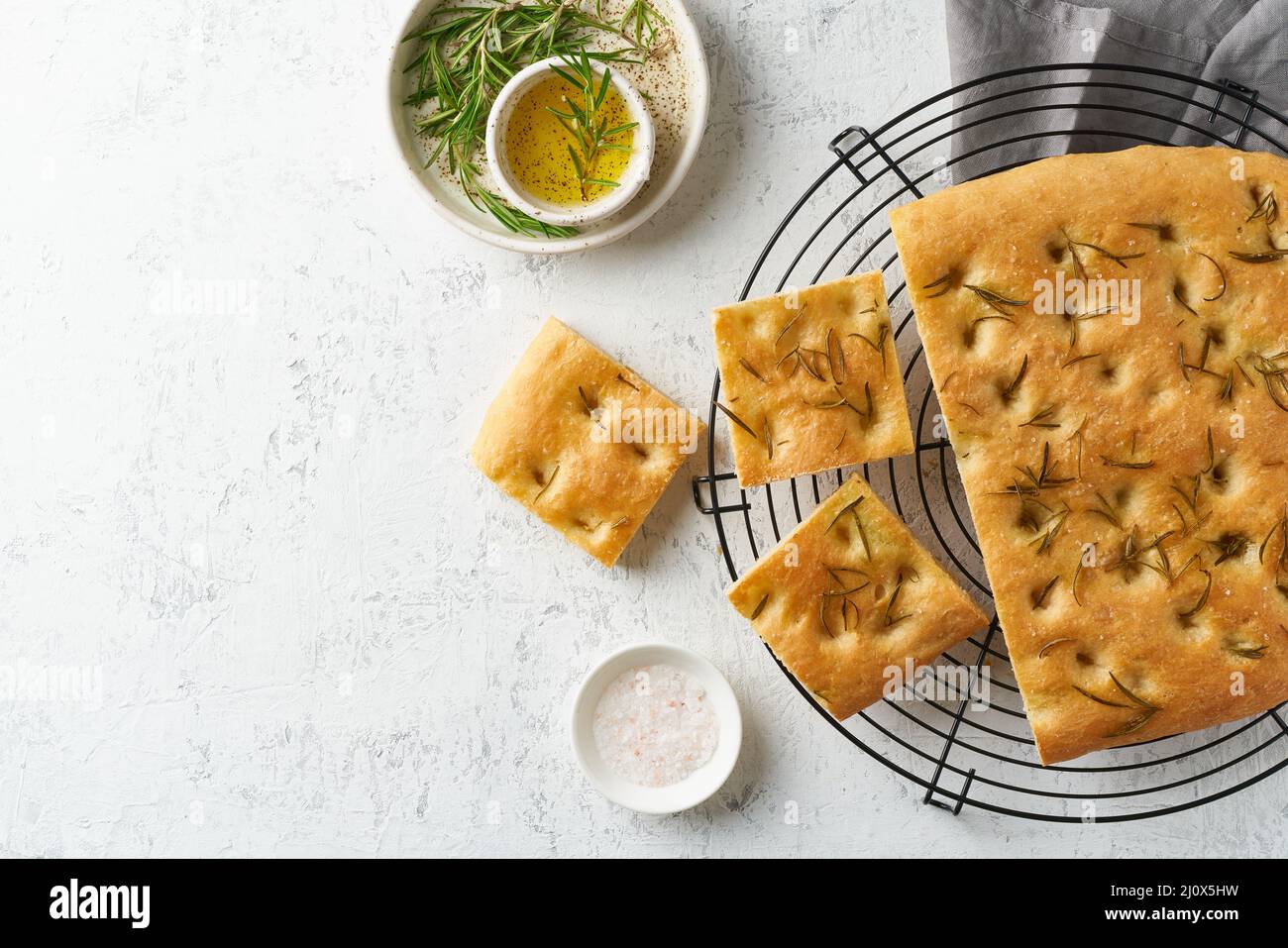 Focaccia, pizza, italian flat bread with rosemary and olive oil on grid ...