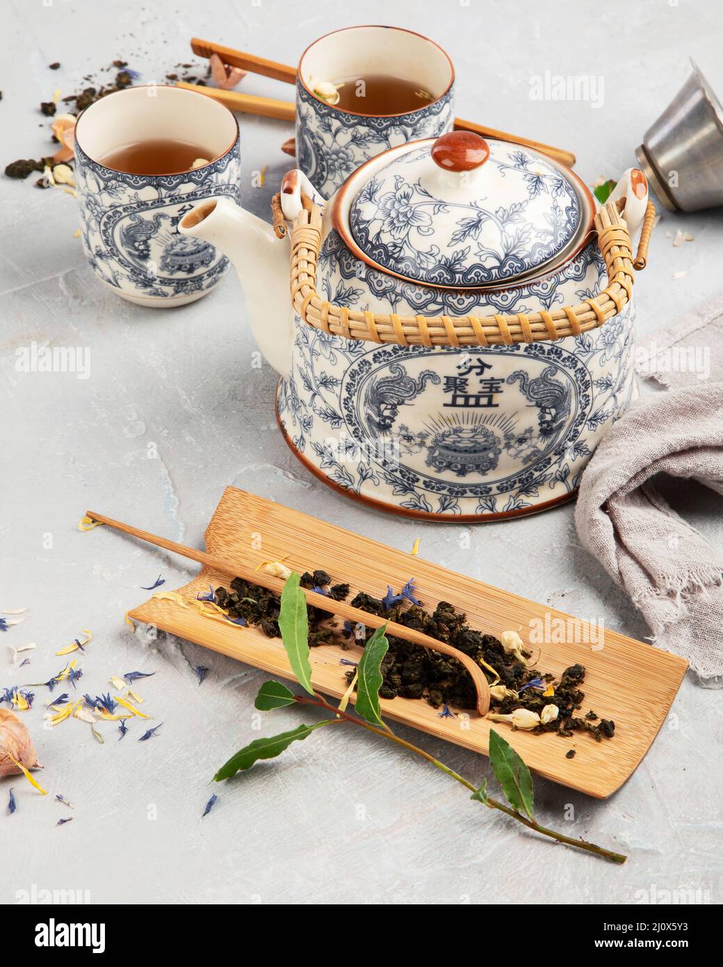 Asian teapot with herbal tea on light background. Plant leaves, natural ...